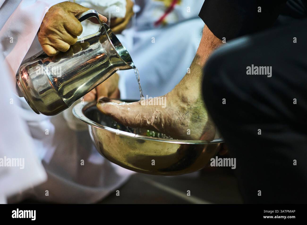 A priest washes the foot of a parishioner during a Holy Week Mass in ...