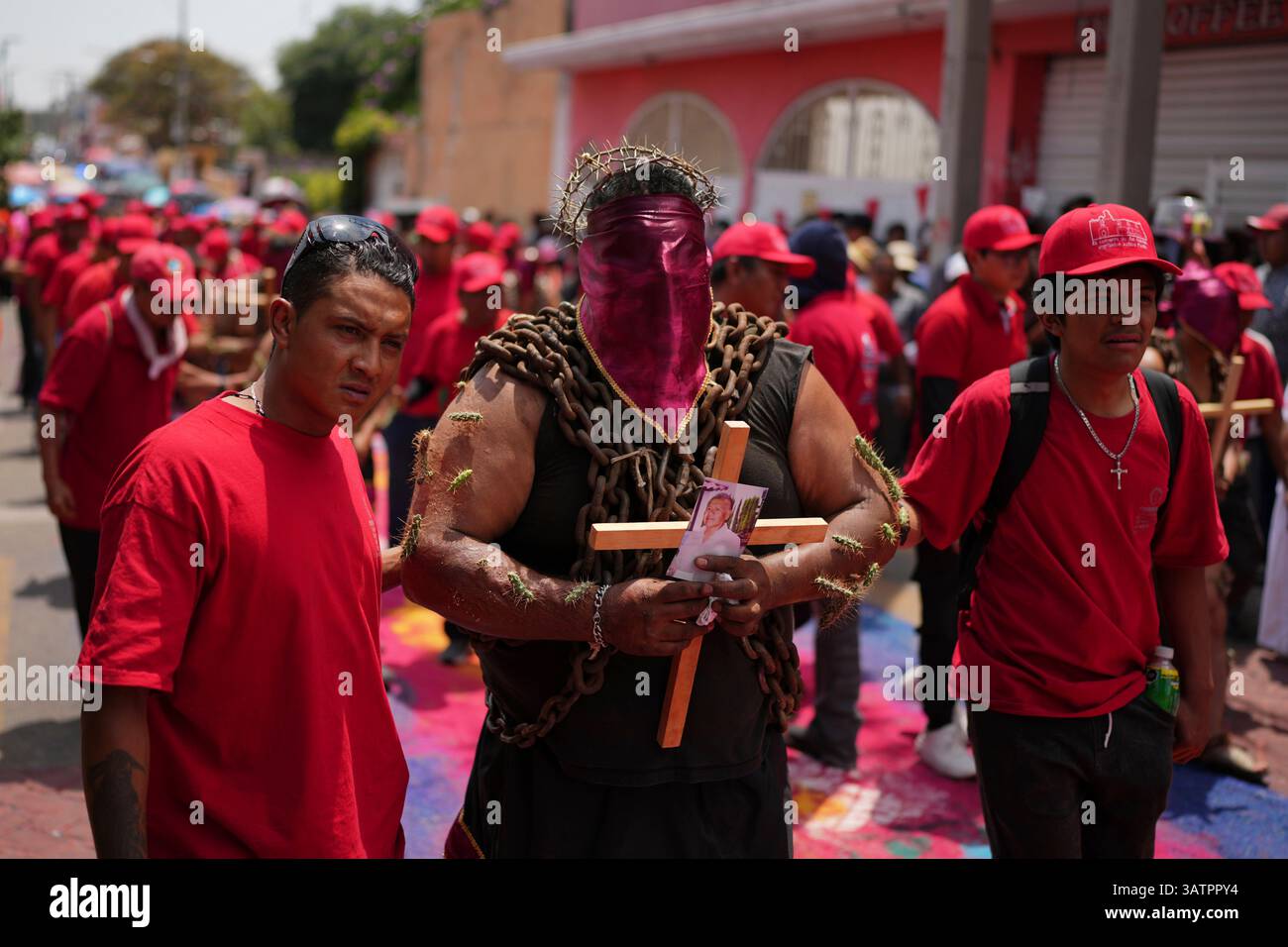 A masked penitent in chains with cacti attached to his arms takes part ...