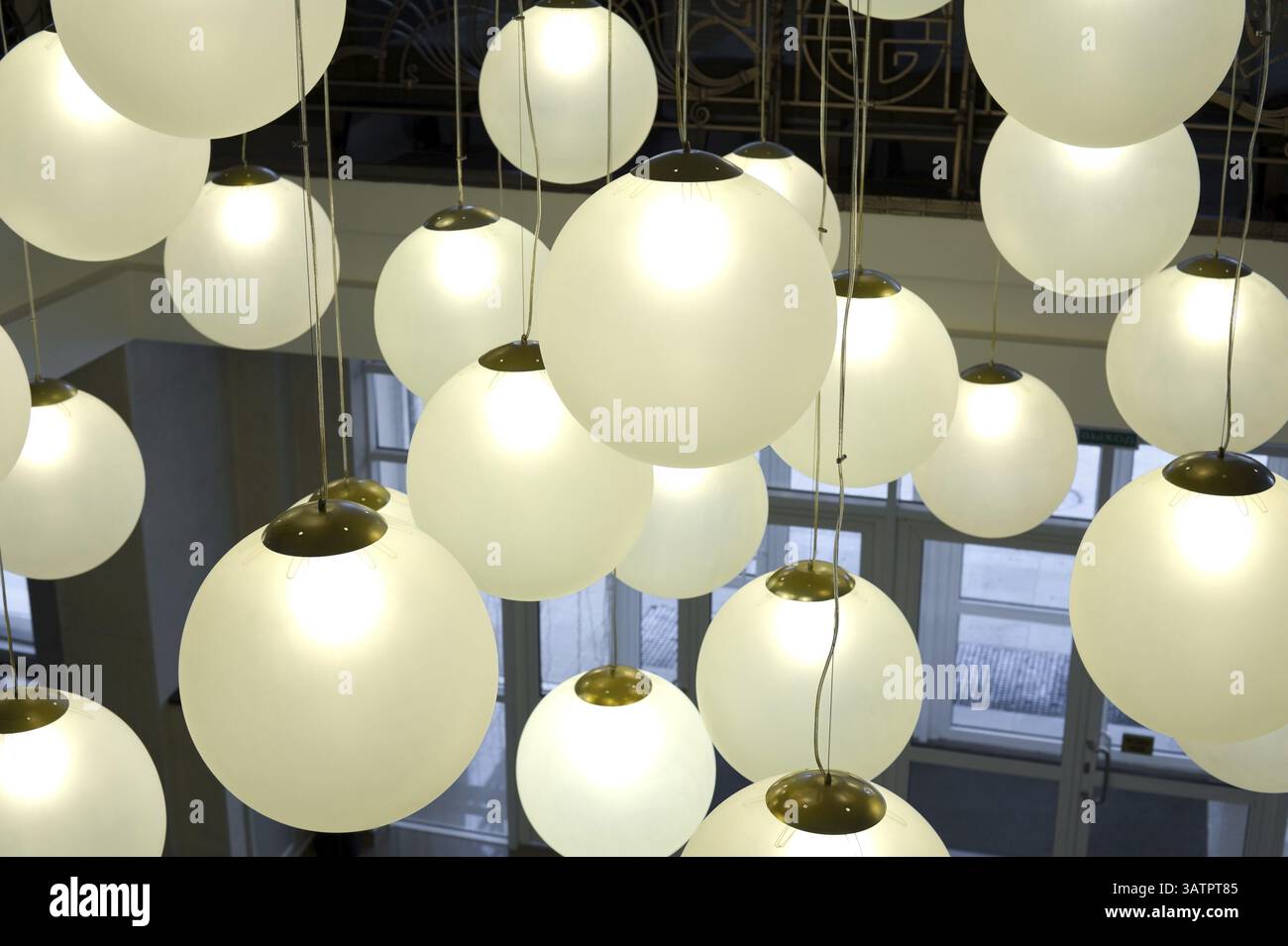 Lots of round lamps hanging on long cords at various height Stock Photo ...