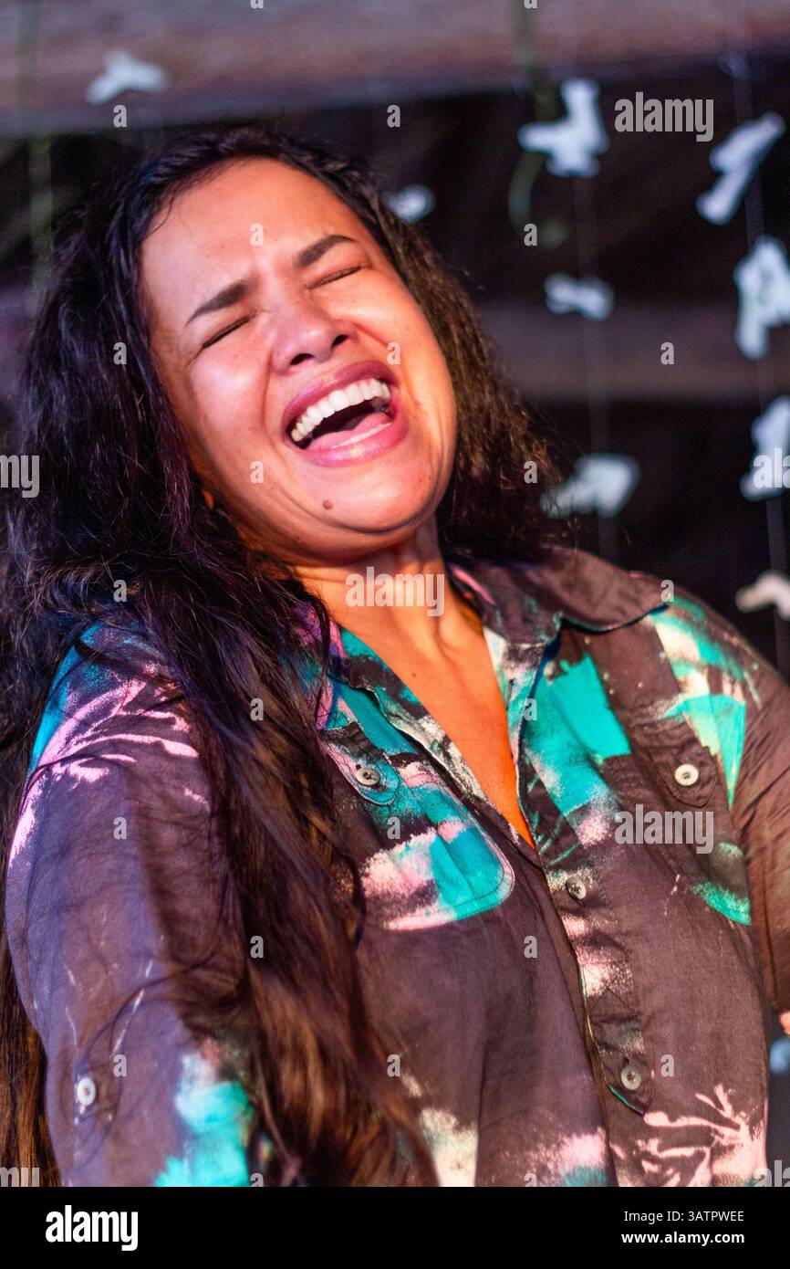 Portrait of a plus sized Latina woman with long hair singing outdoors ...