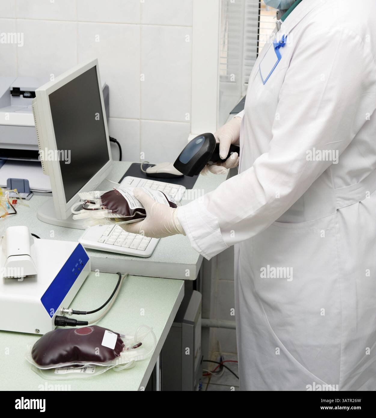 Nurse feeds data of new donor blood into the database at ...