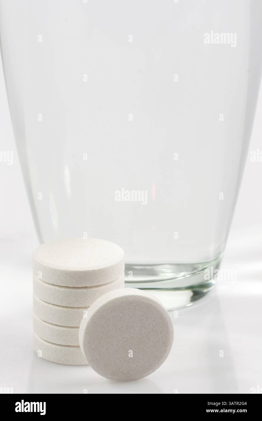 Close-up of effervescent tablets in front of a glass Stock Photo - Alamy