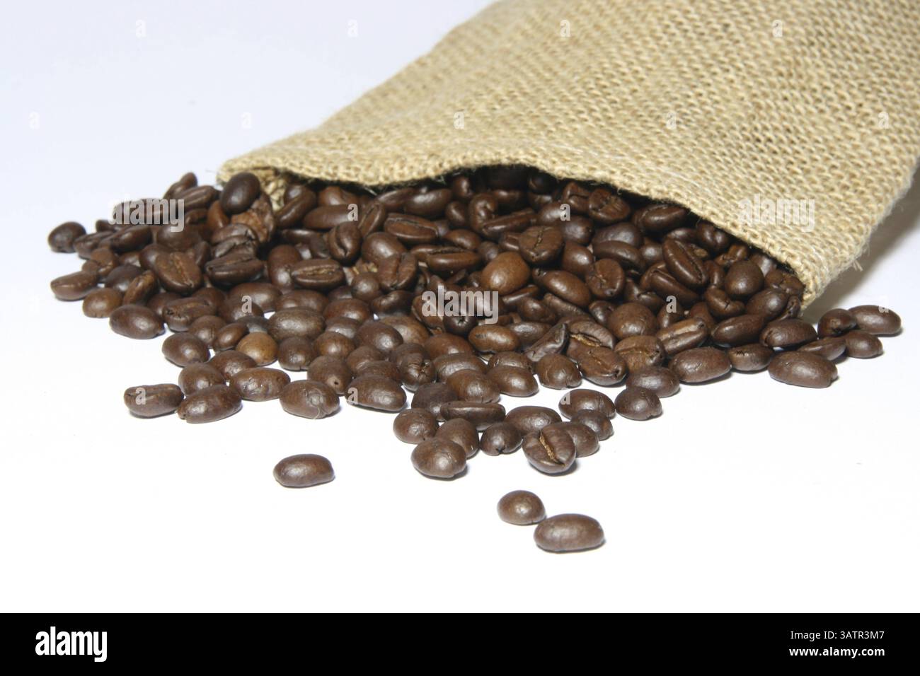 Roasted coffee beans in a sack - some coffee beans and a jute sack Stock Photo - Alamy