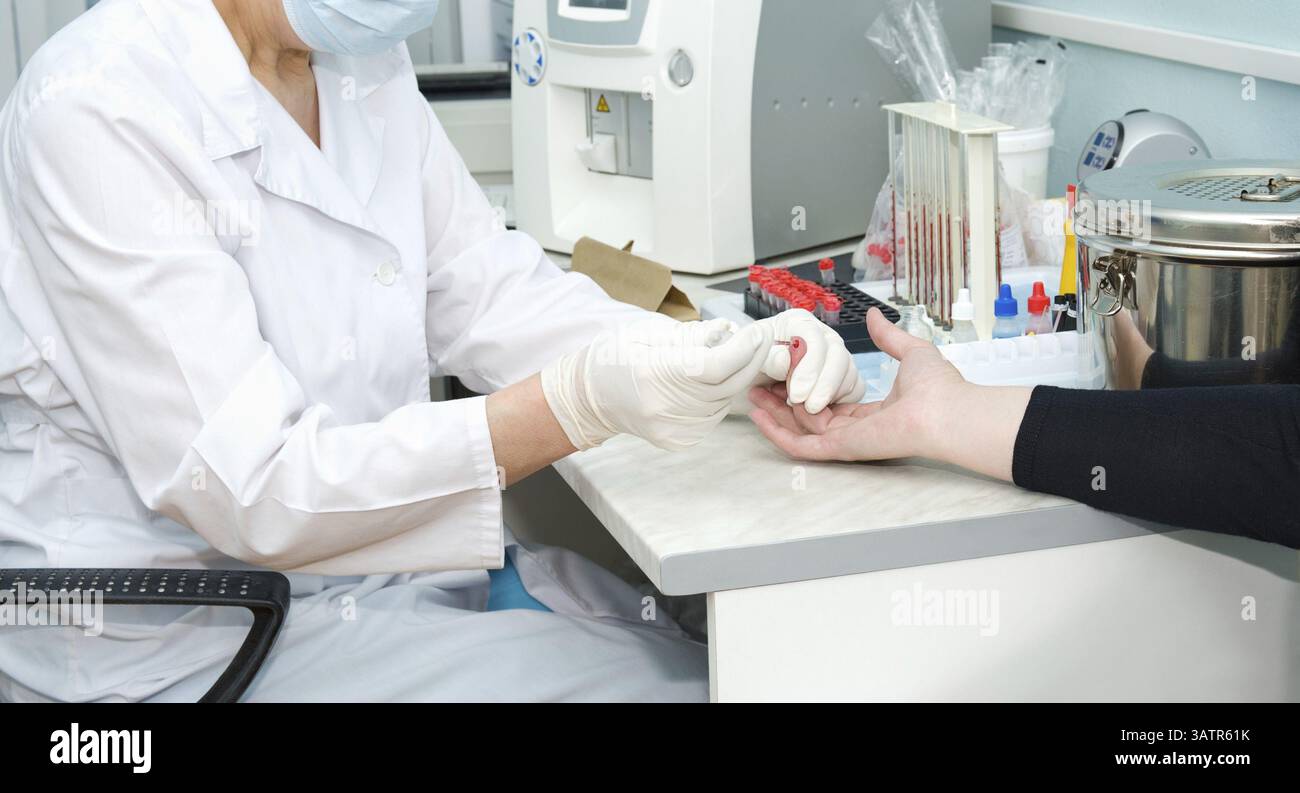 A nurse collects a blood specimen from a finger Stock Photo - Alamy