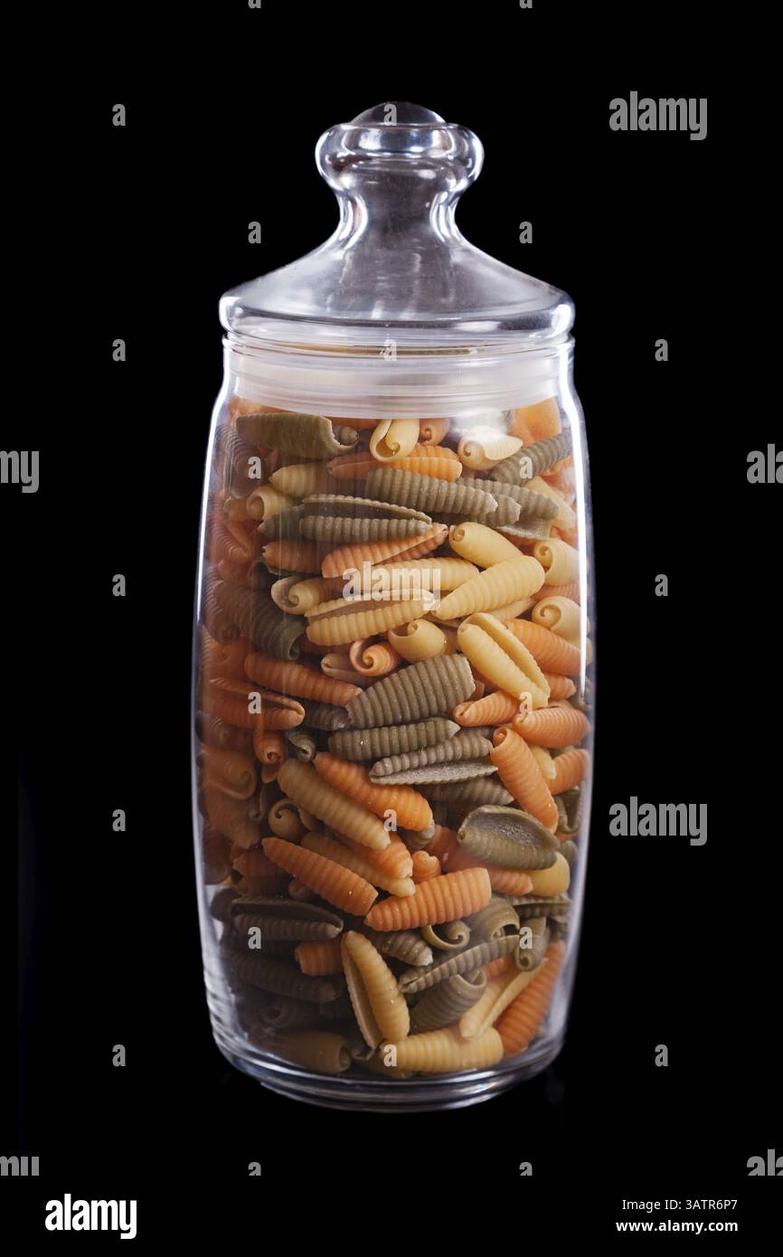 Spaghetti shells in the glass pot isolated on black background Stock ...