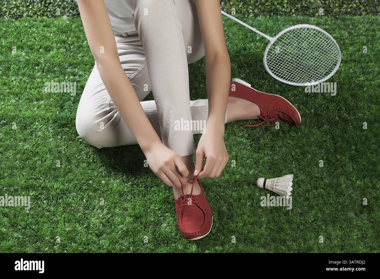 Woman's legs, badminton racket and shuttlecock on a green grass Stock ...
