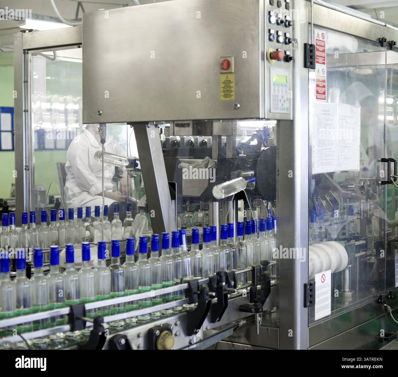 An operator monitors vodka limpidity at a production line Stock Photo ...