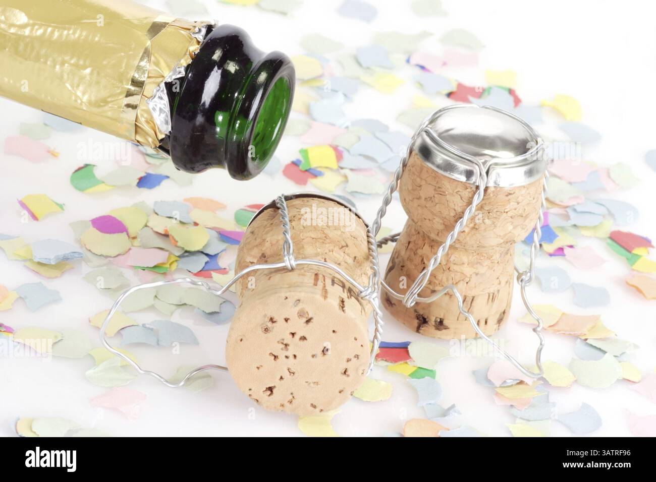 Empty champagne bottle, two champagne corks and confetti on a white ...