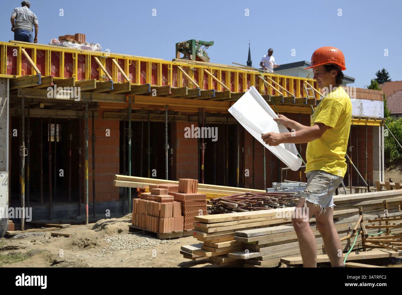 Construction foreman checks the construction site against the plan ...