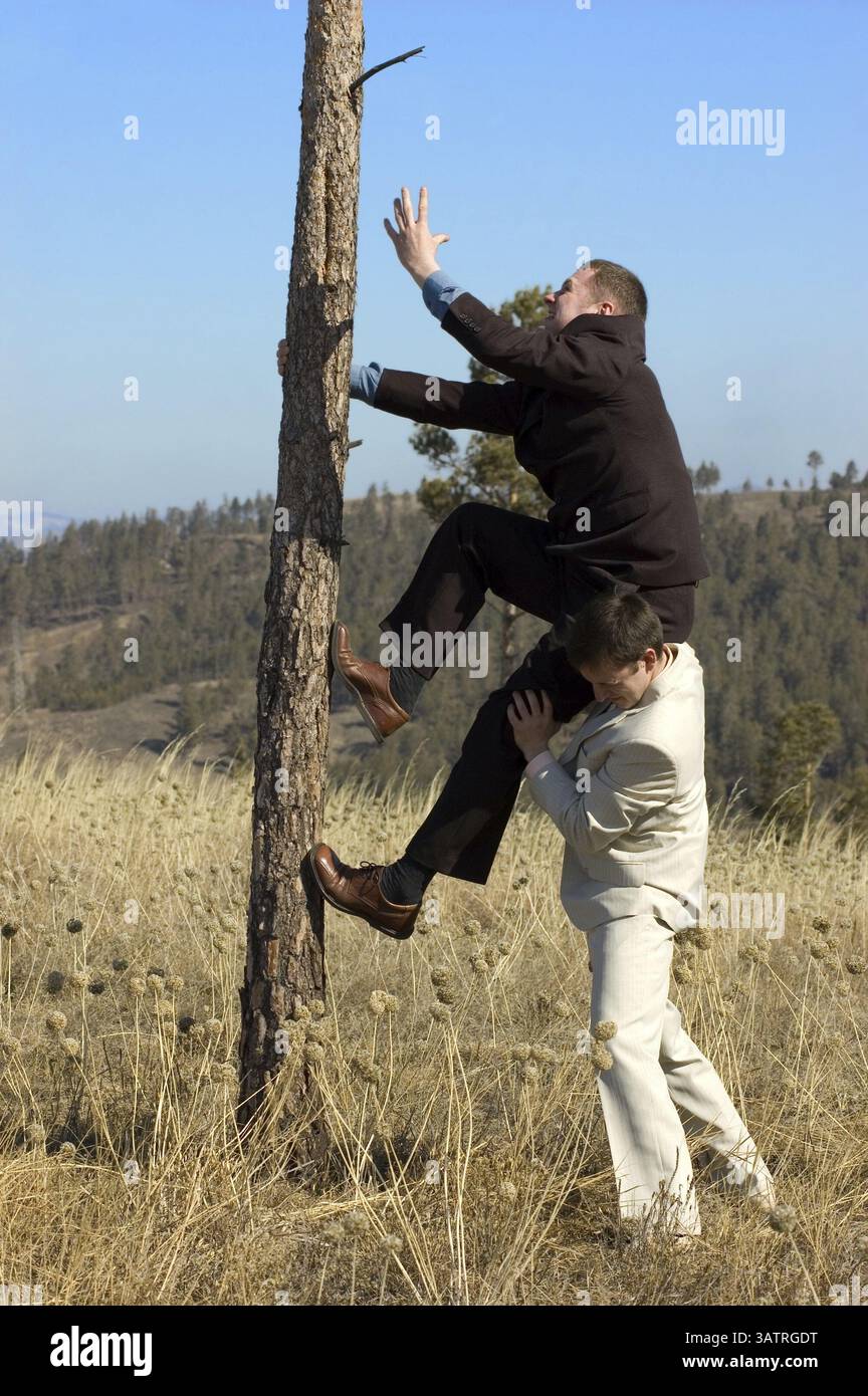 Man helping another man climb hi-res stock photography and images - Alamy