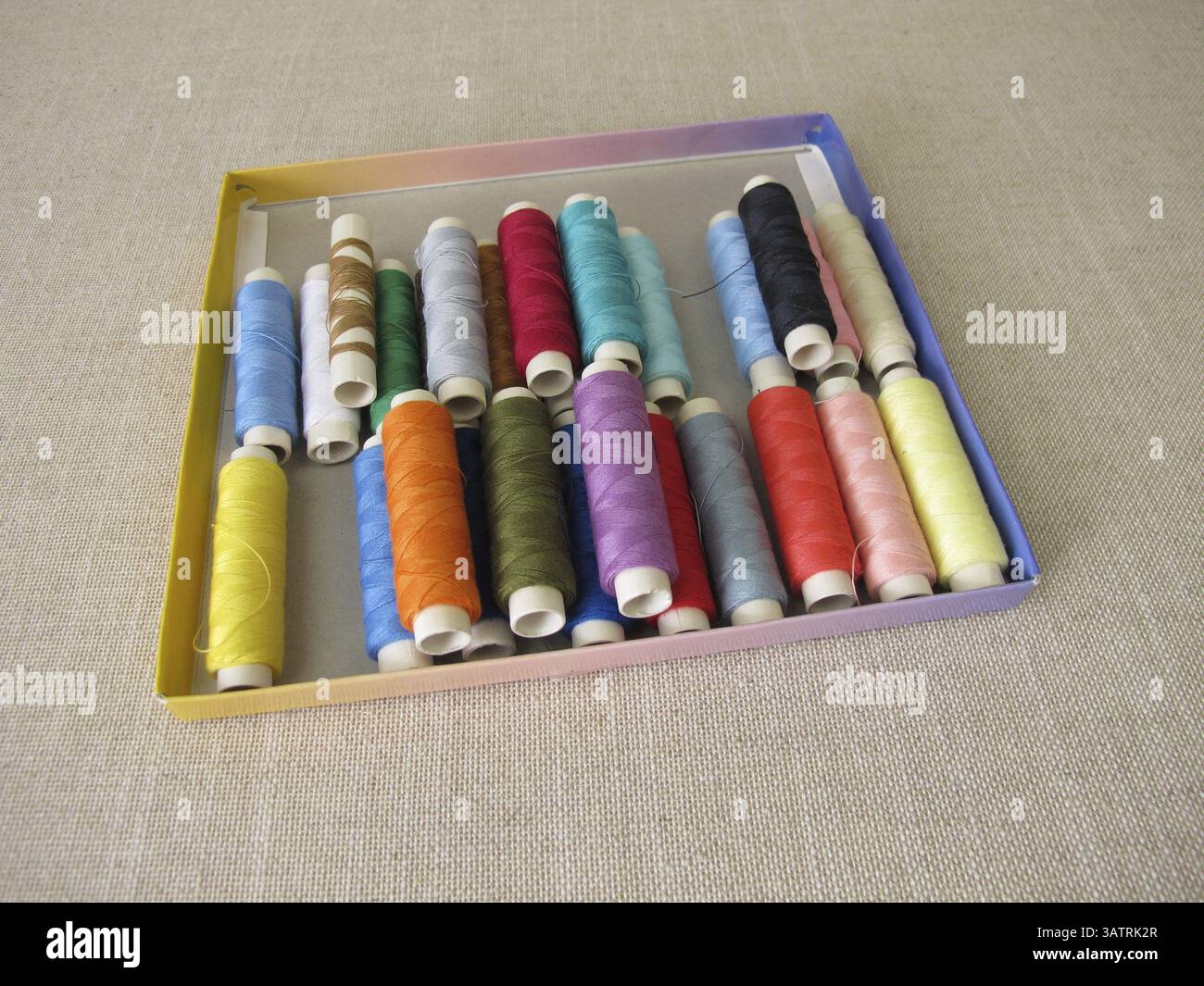 Sewing thread in different colours in a box Stock Photo - Alamy