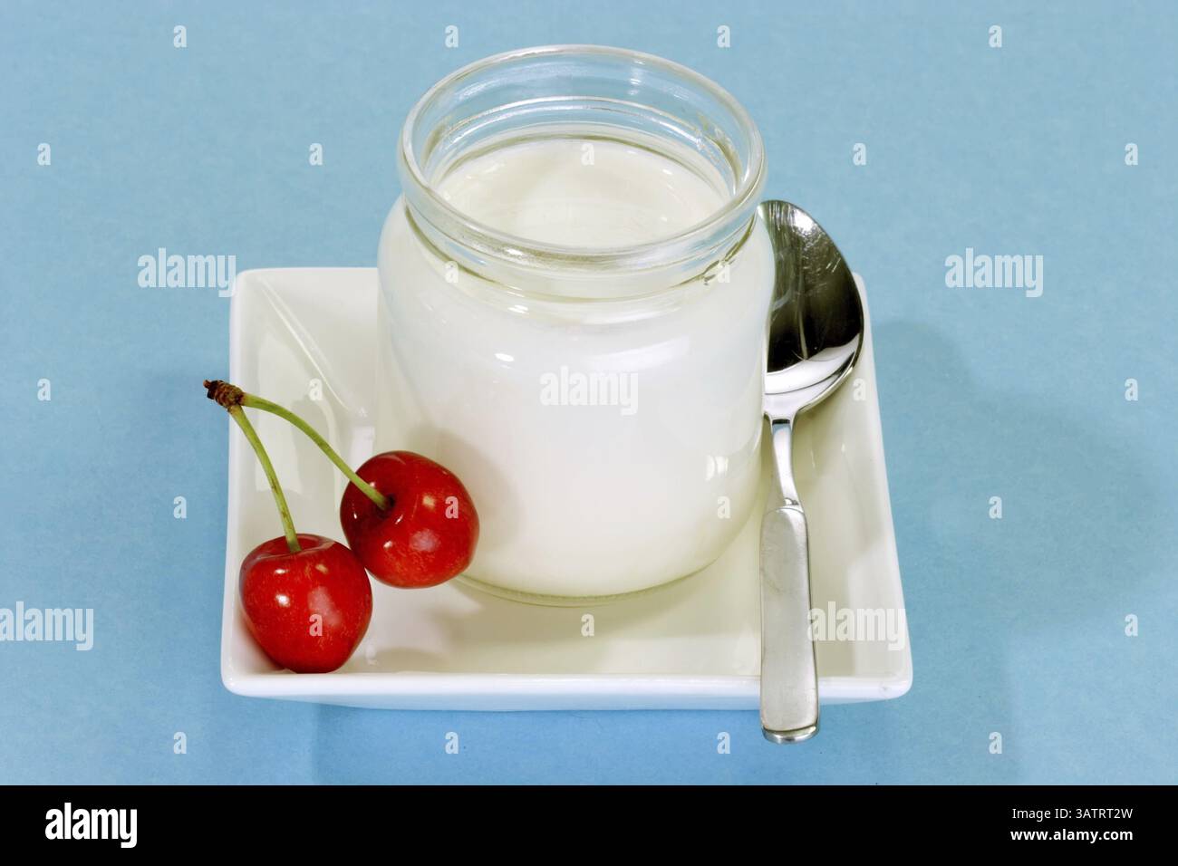 Yoghurt with fresh cherries on a light blue background Yoghourt in a ...