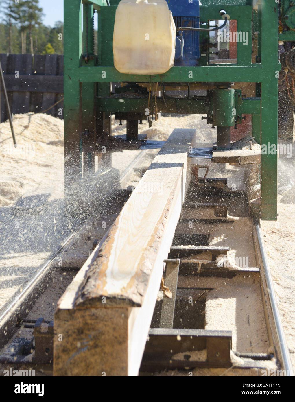 At powersaw bench - workers make a squared beam from a log Stock Photo ...