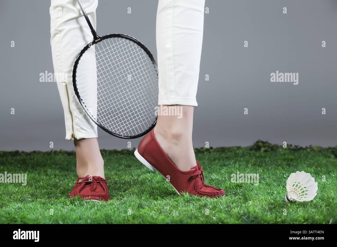 Woman's legs, badminton racket and shuttlecock on a green grass Stock ...