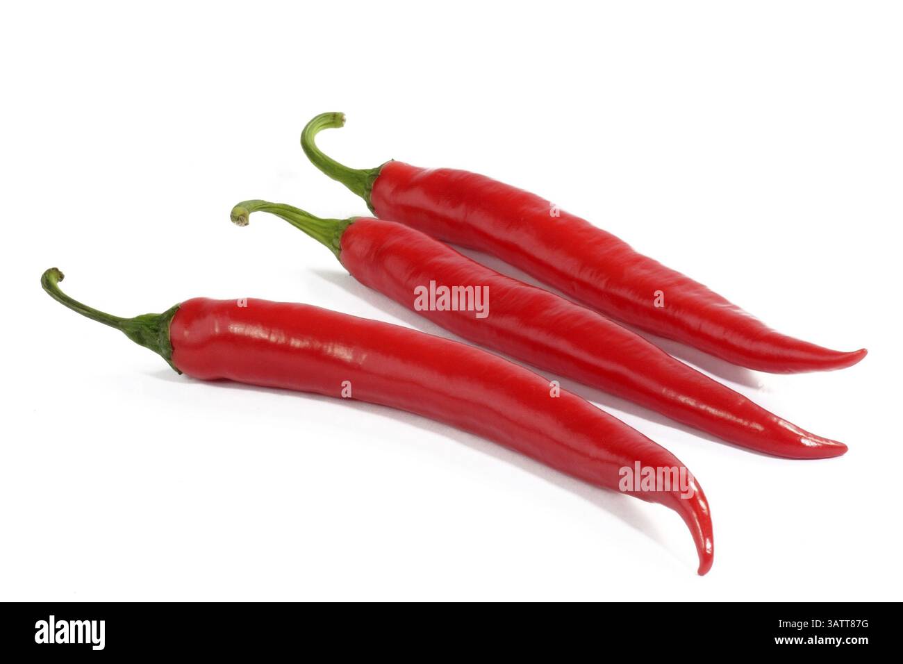 Three red chilli peppers lying on white background Three red chilli ...