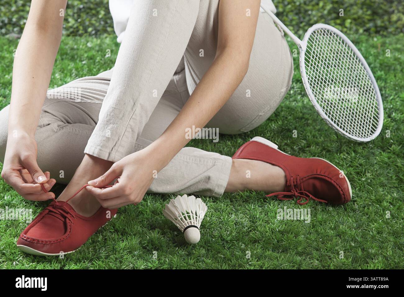 Woman's legs, badminton racket and shuttlecock on a green grass Stock ...