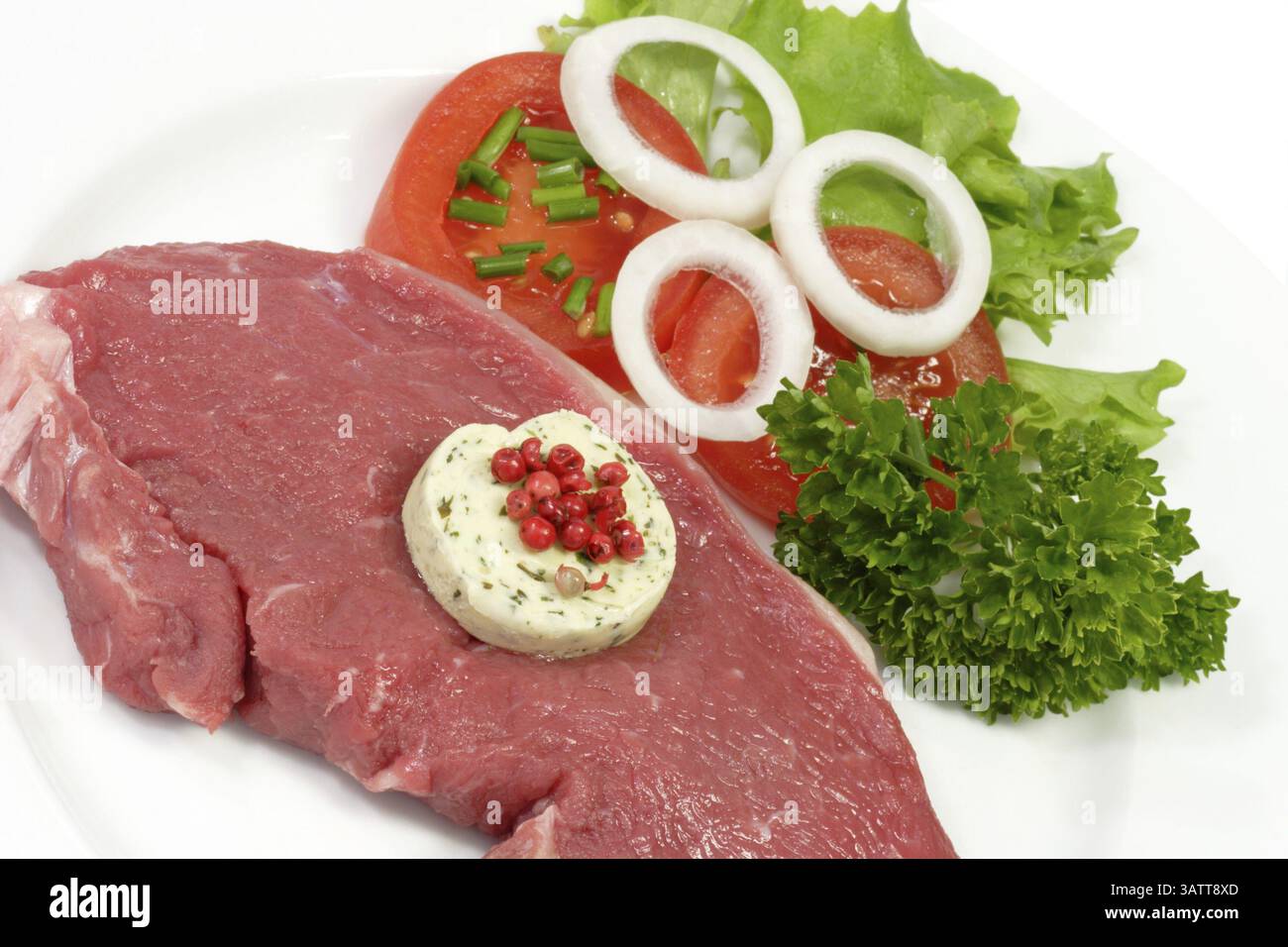 Garnished raw rump steak on a plate Rare garnished rump steak on a ...