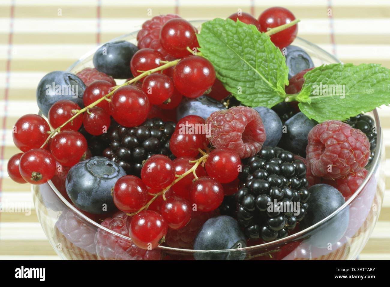 Different types of berries with peppermint leaves in a glass Stock ...