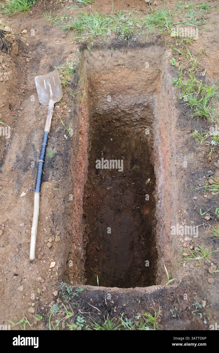 Grave - just been digged, spade by the edge Stock Photo - Alamy