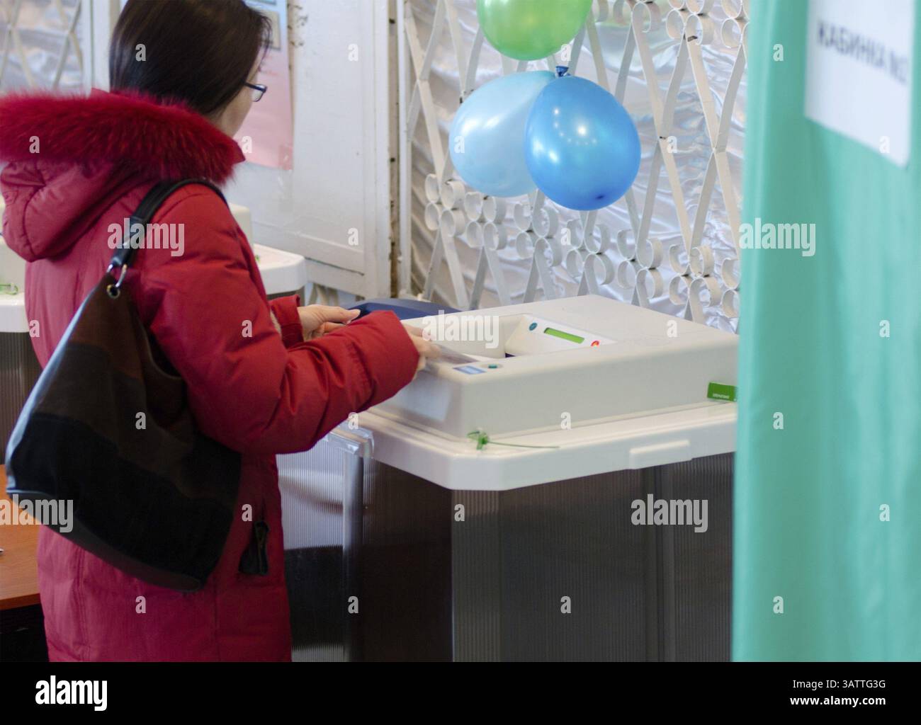 A woman drops a ballot for voting into an electronic ballot box at the ...