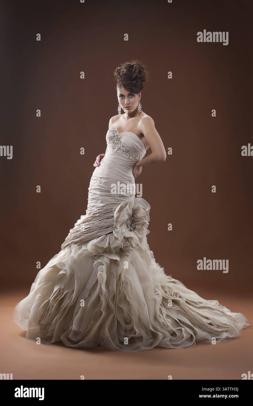 Young beautiful woman in a wedding dress on a studio background Stock ...
