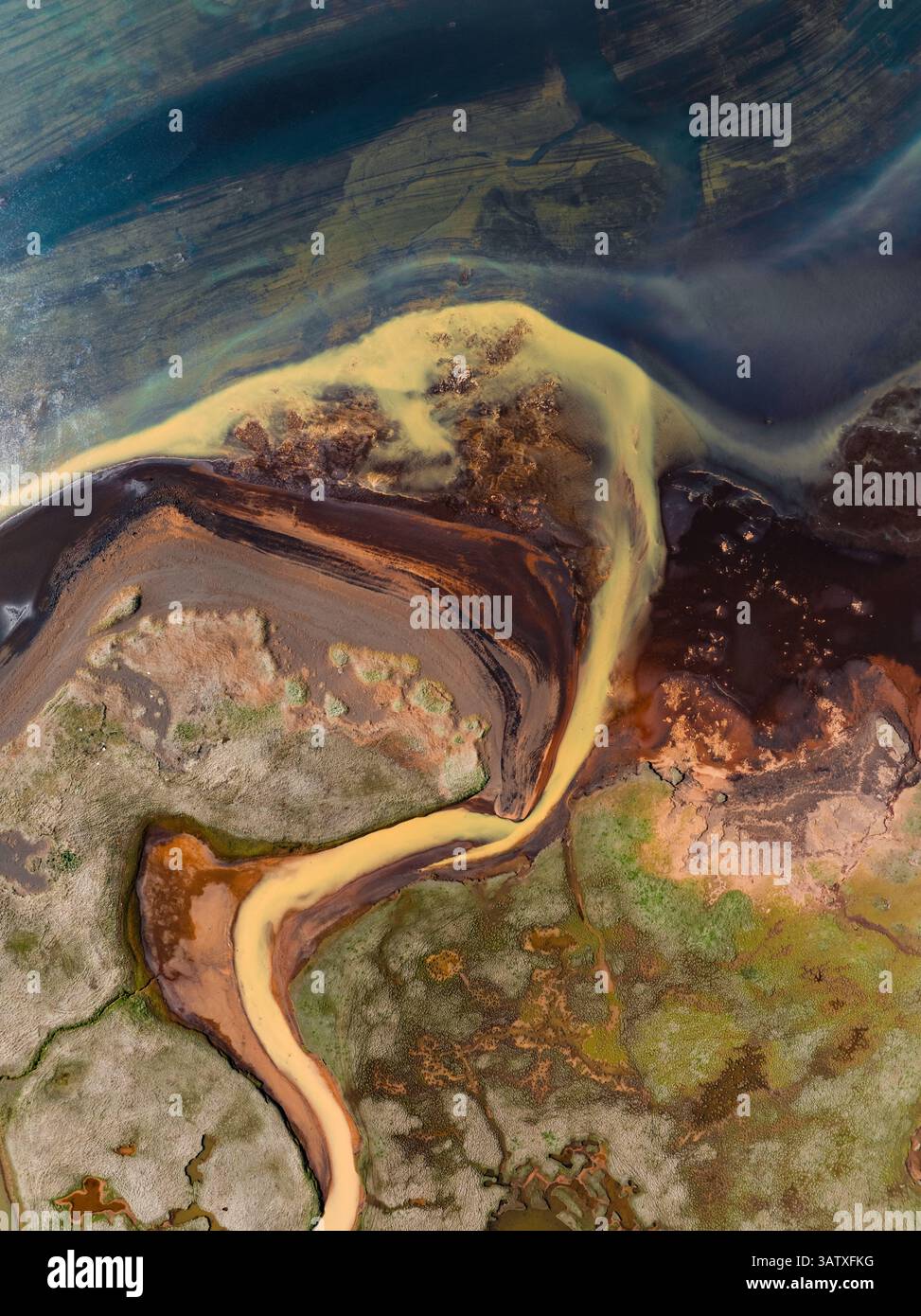 Abstract aerial of a delta where yellow and black sediments meet the ...