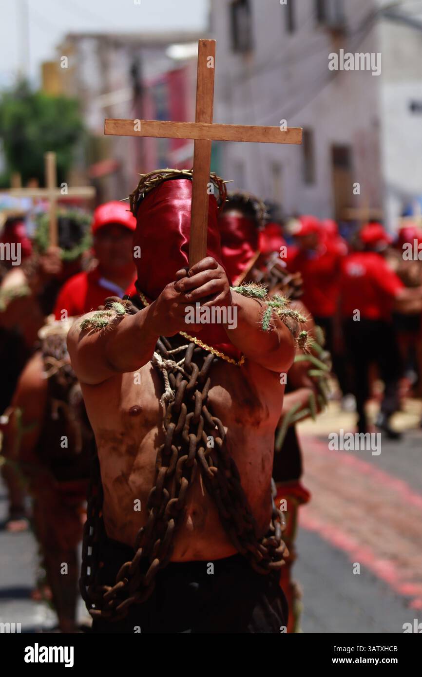 Atlixco, Mexico. 18th Apr, 2025. A penitent hooded carry heavy chains ...