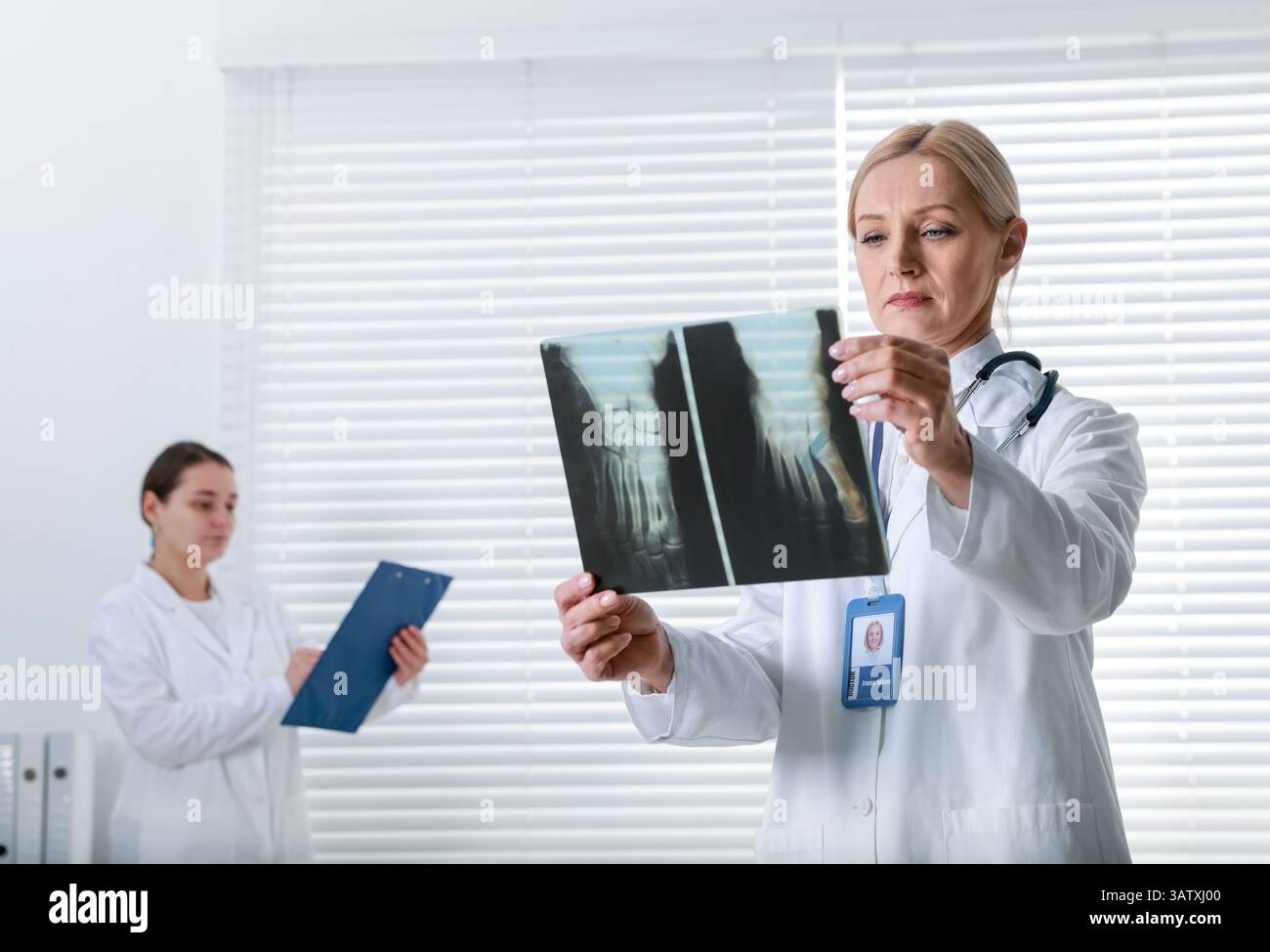 Doctor examining x-ray image of foot in clinic. Medical assistant with ...