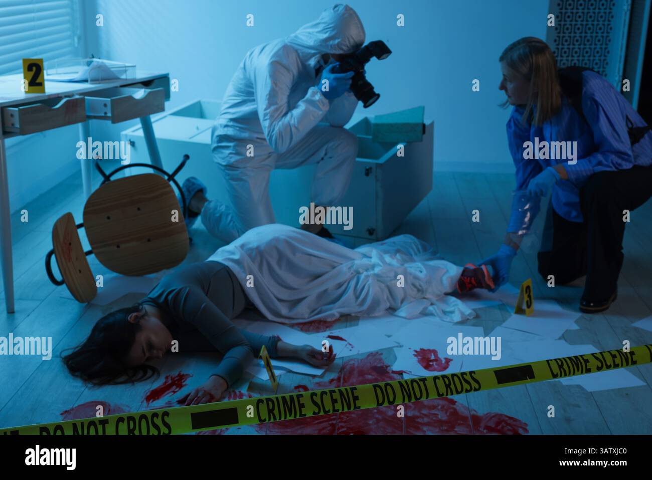 Forensic experts working at crime scene with dead woman's body indoors ...