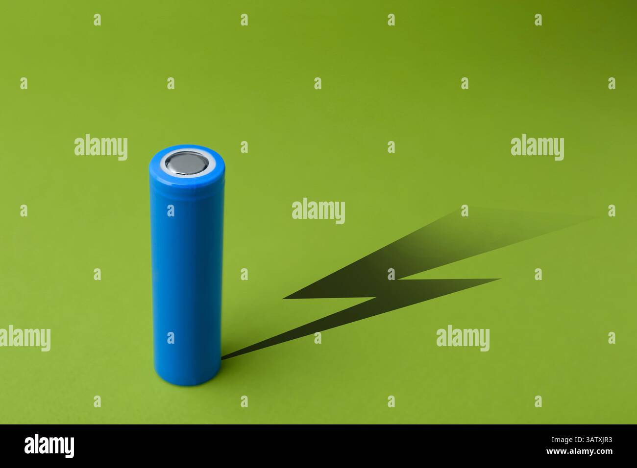 Alkaline battery with shadow in shape of lightning on green background ...