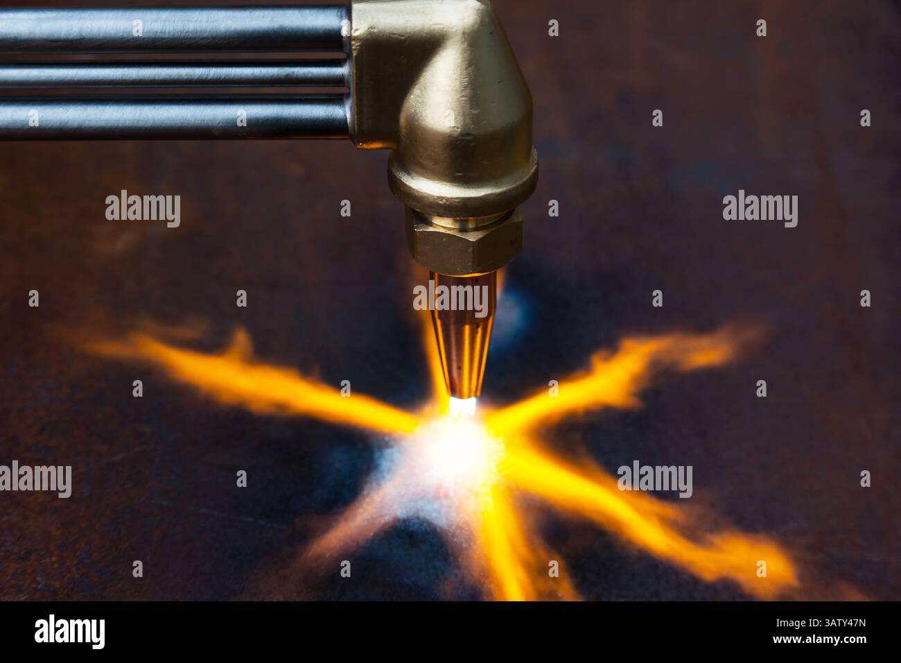 Gas cutting of metal. Gas cutter with copper nozzle with a stream of ...