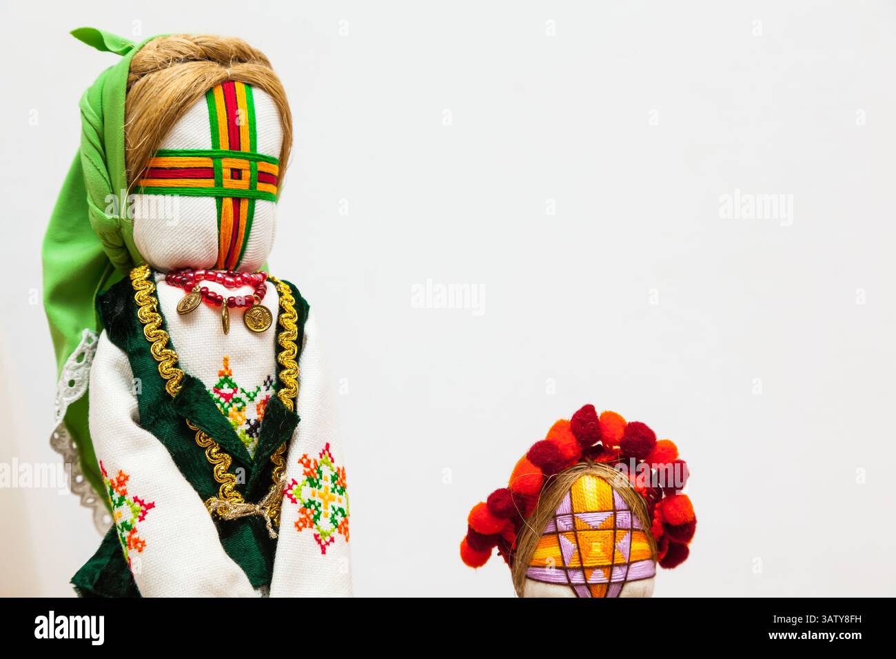 Handmade soft toys dressed in traditional rustic outfits on a white ...