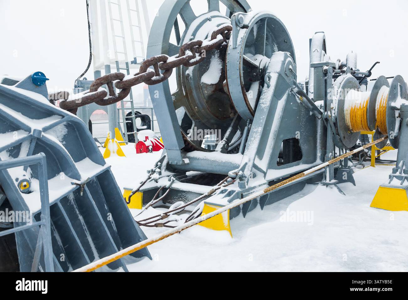 The mooring deck of a cargo ship with anchor winches, an anchor chain ...