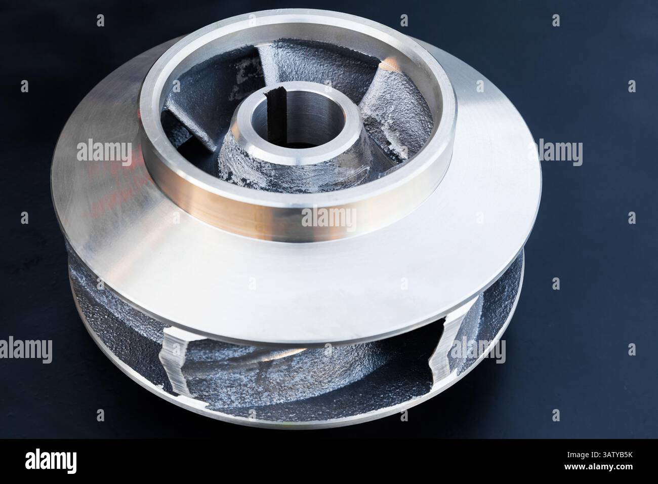 New bronze impeller on a dark blue background, top view Stock Photo - Alamy