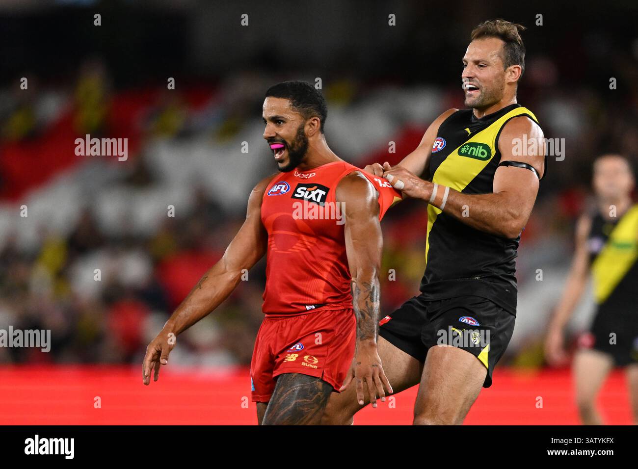 Touk Miller of the Suns is held back in a scuffle by Toby Nankervis of ...