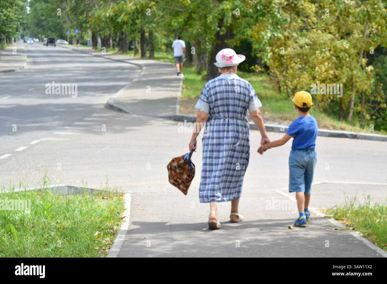 Granny and grandson crossing the road in city Stock Photo - Alamy