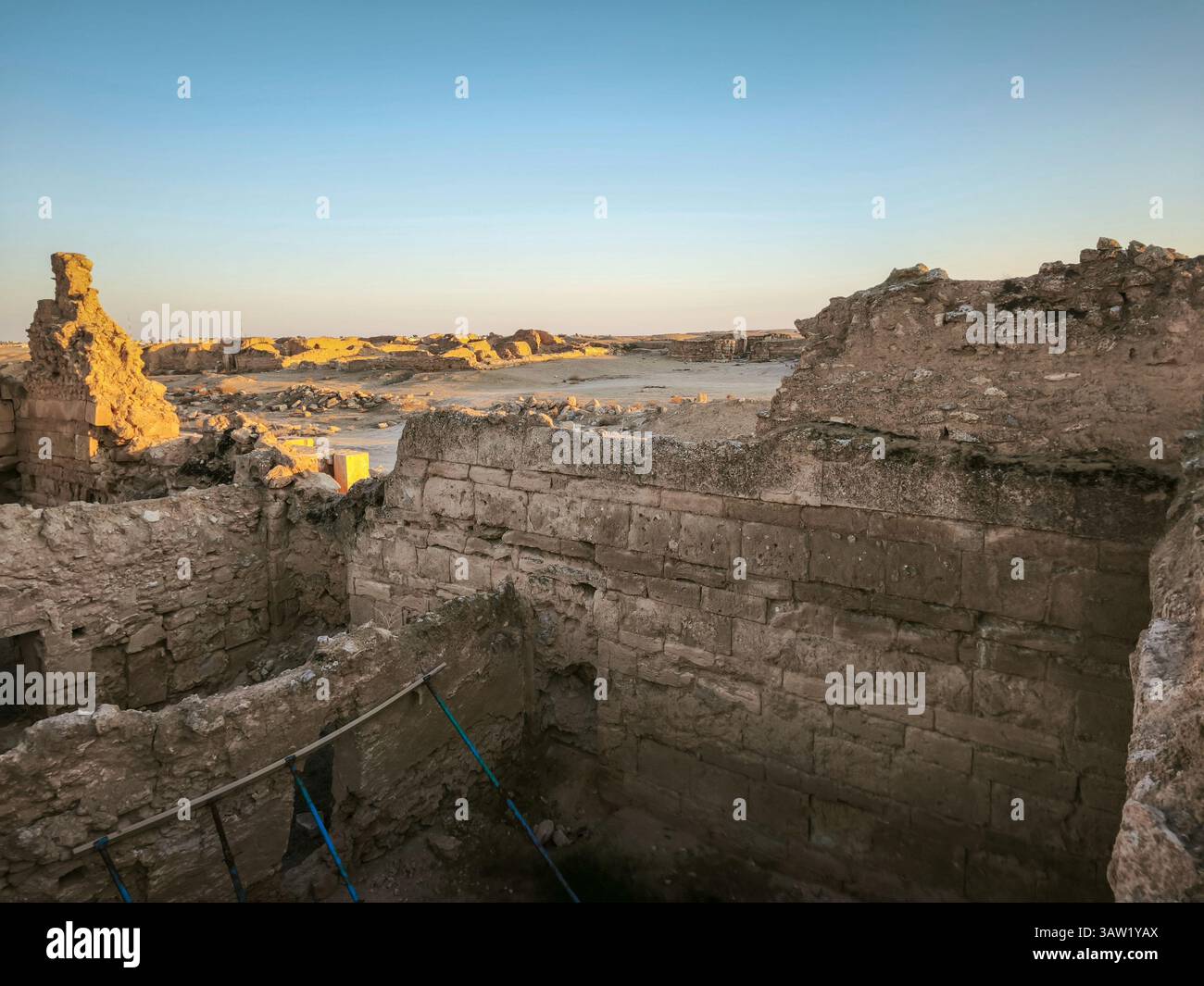 Ancient ruins under a clear blue sky, with scattered stones and desert ...