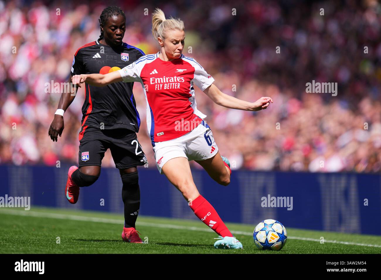 Arsenal's Leah Williamson crosses the ball in front of Lyon's Tabitha ...