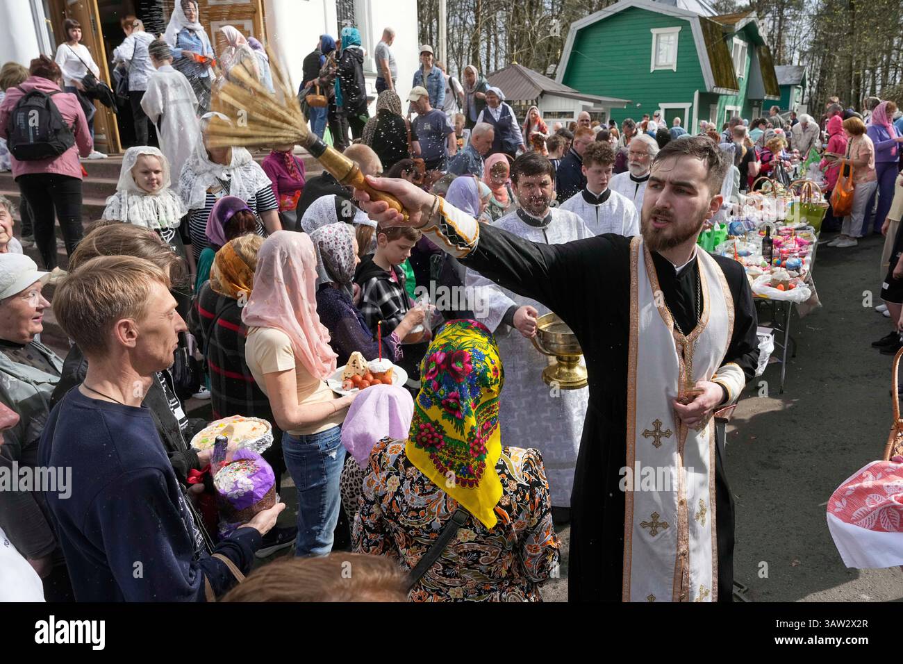 An Orthodox priest blesses believers and their traditional Easter cakes ...