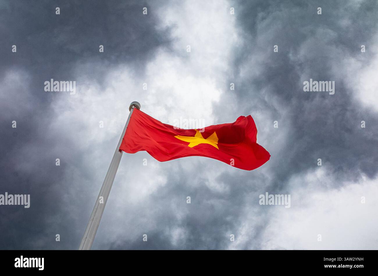 A stormy sky and the giant red with a gold-star Vietnamese flag that ...