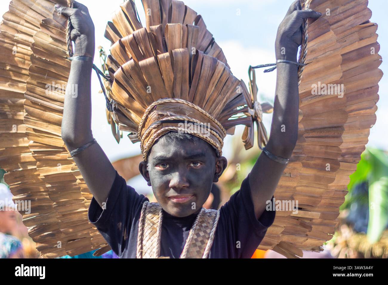Participant in black face paint to honor the Ati tribe and wearing ...