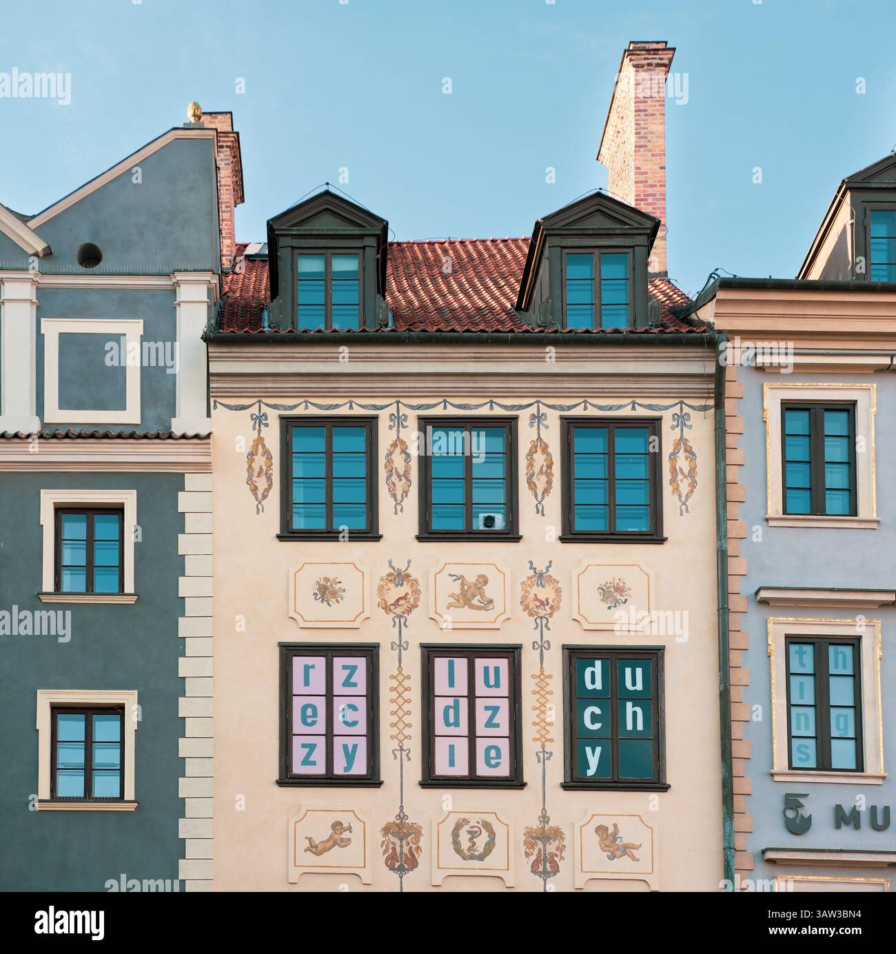 A close-up view of three adjacent buildings, showcasing varying architectural styles and colors ...