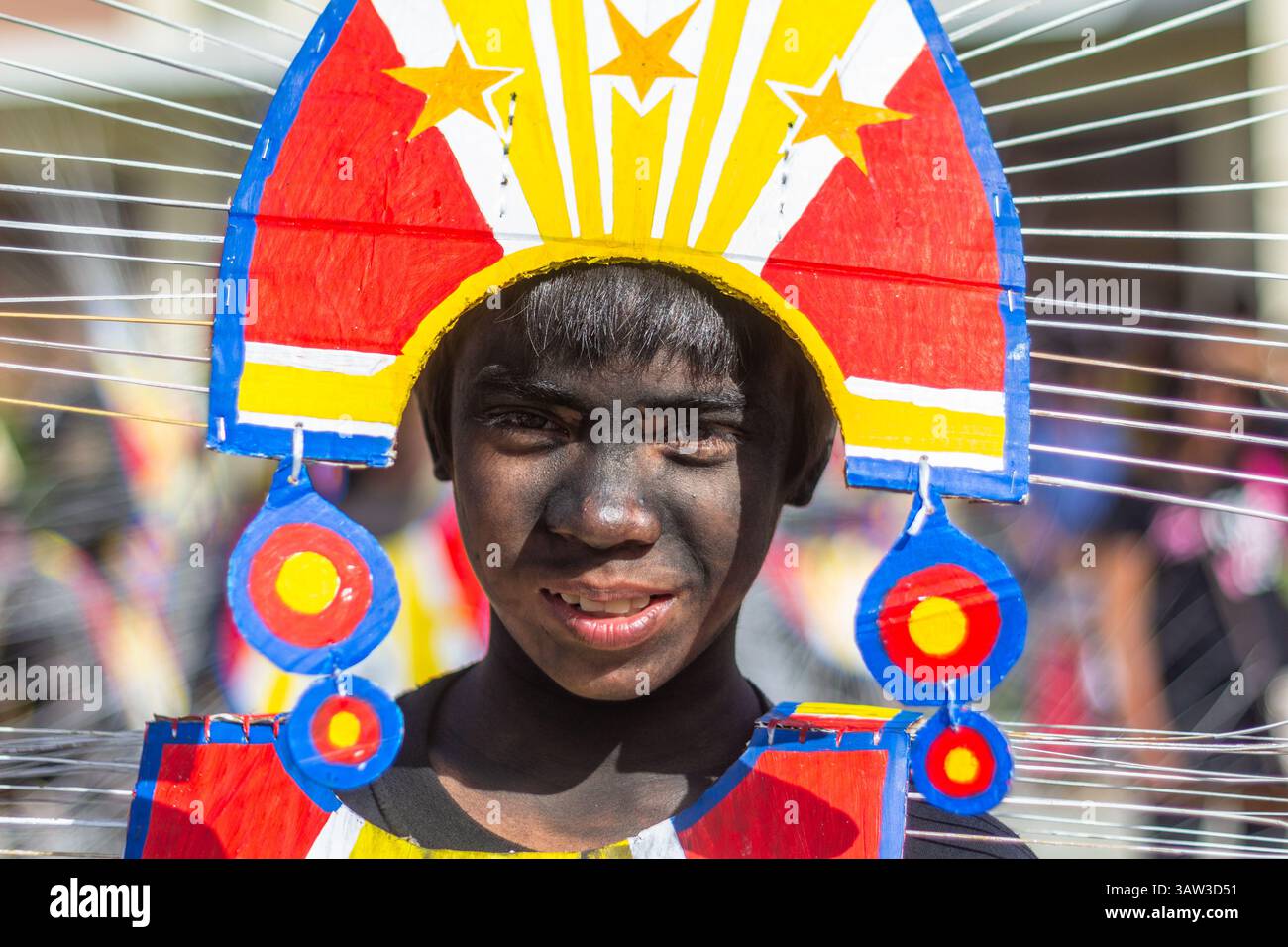 Participant in black face paint to honor the Ati tribe and wearing ...