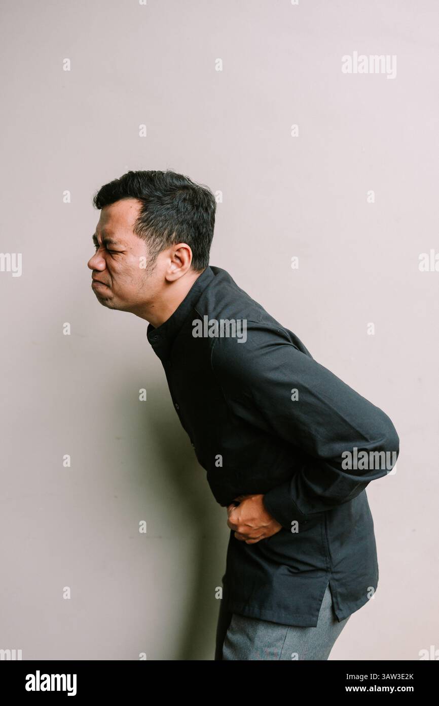 Man expressing sharp abdominal pain. Person holding his stomach in ...