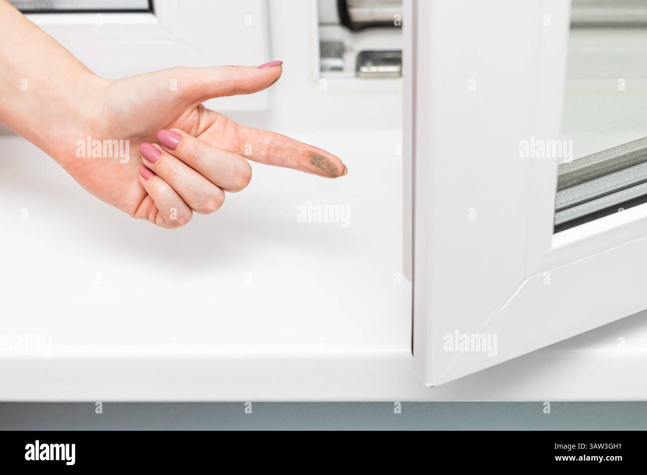 woman shows dirt accumulated on window, close-up. dirty plastic window ...