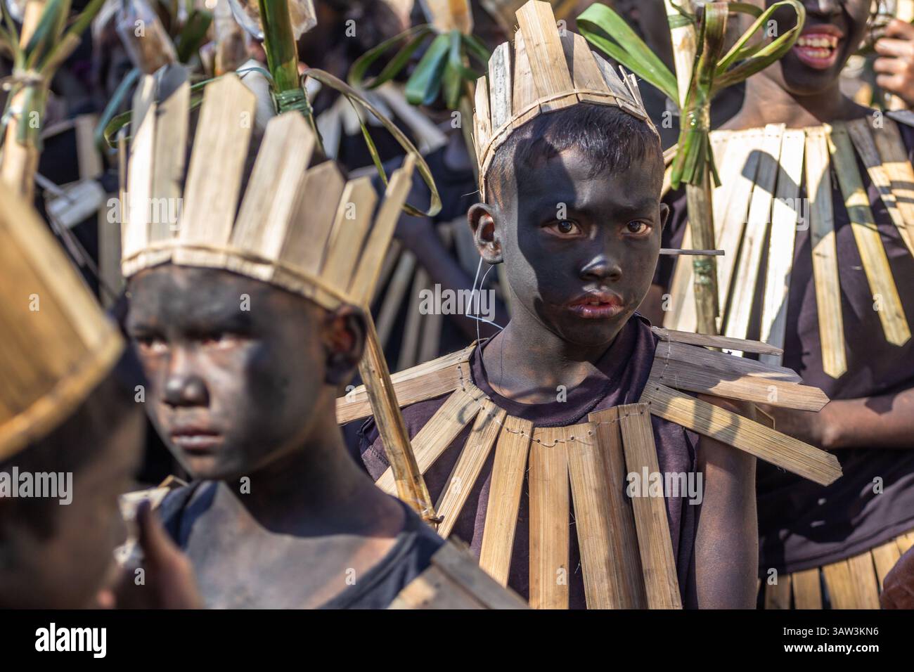 Two boys covered in black paint and wearing dried leaf costumes during ...