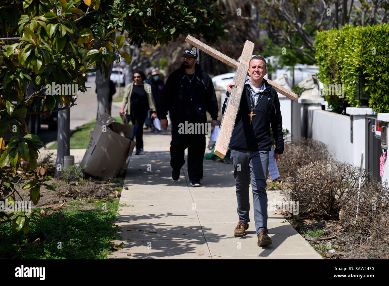 Pastor John Shaver, right, carries a cross during a Cross Walk event by ...