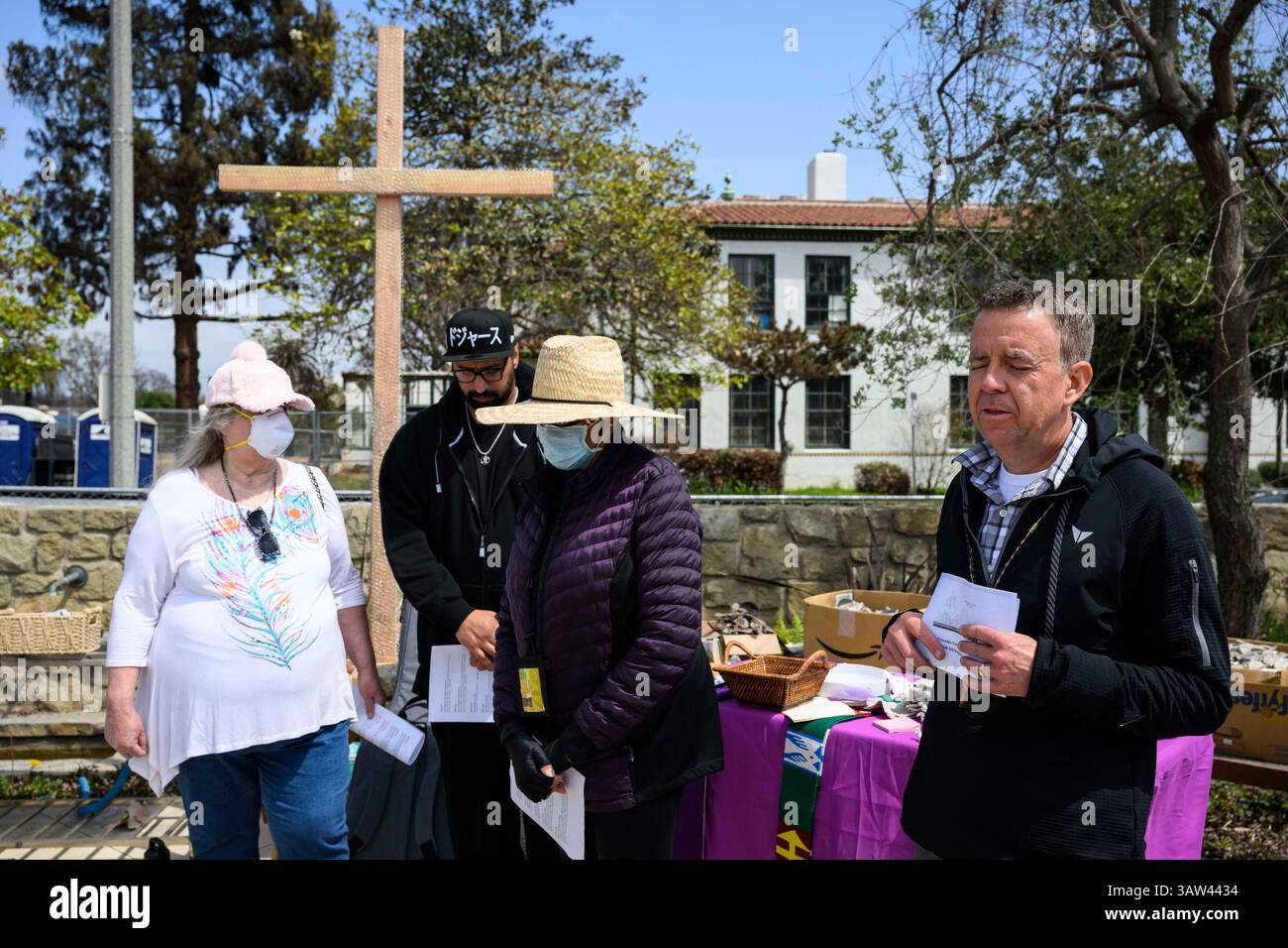 Members of a church listen to a prayer by Pastor John Shaver, right ...