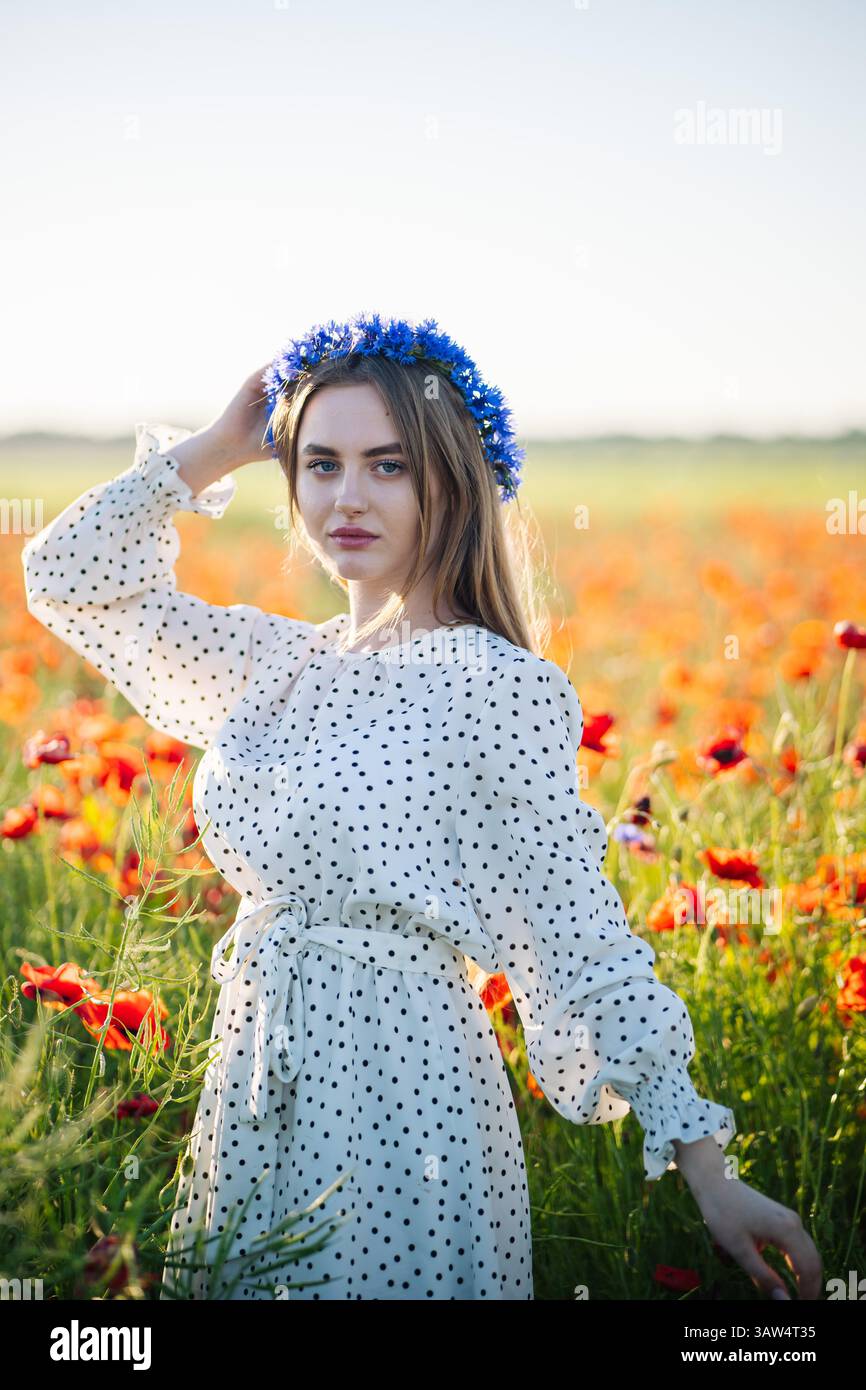 Beautiful slavic woman wearing blue flower crown posing in a poppy ...