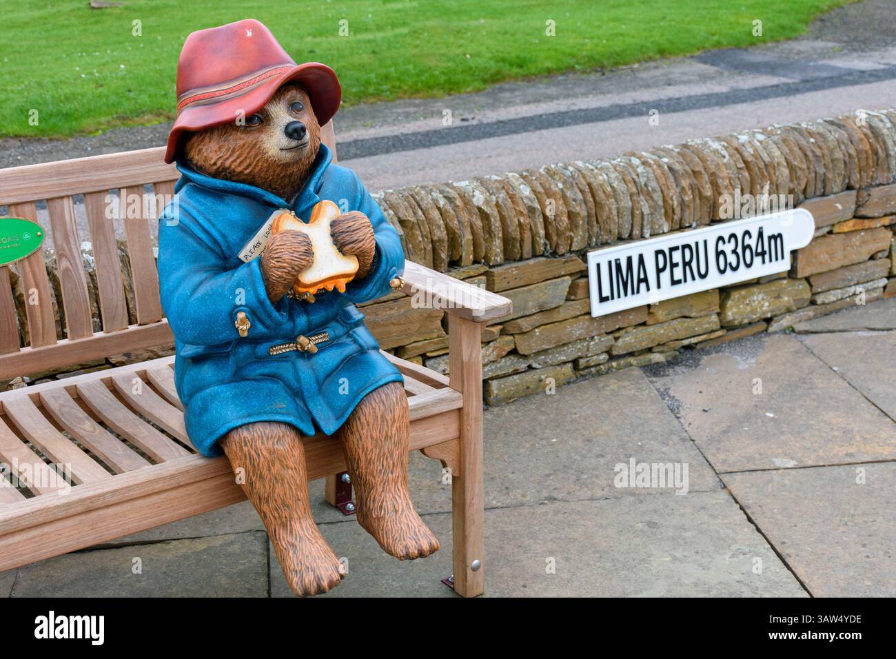 Statue of Paddington Bear sitting on a bench eating a marmalade ...